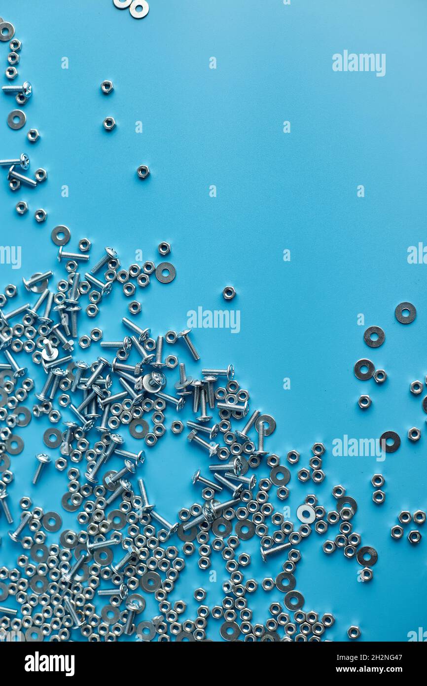 Top view, flat lay Metal screw, nuts and bolts on blue background ...
