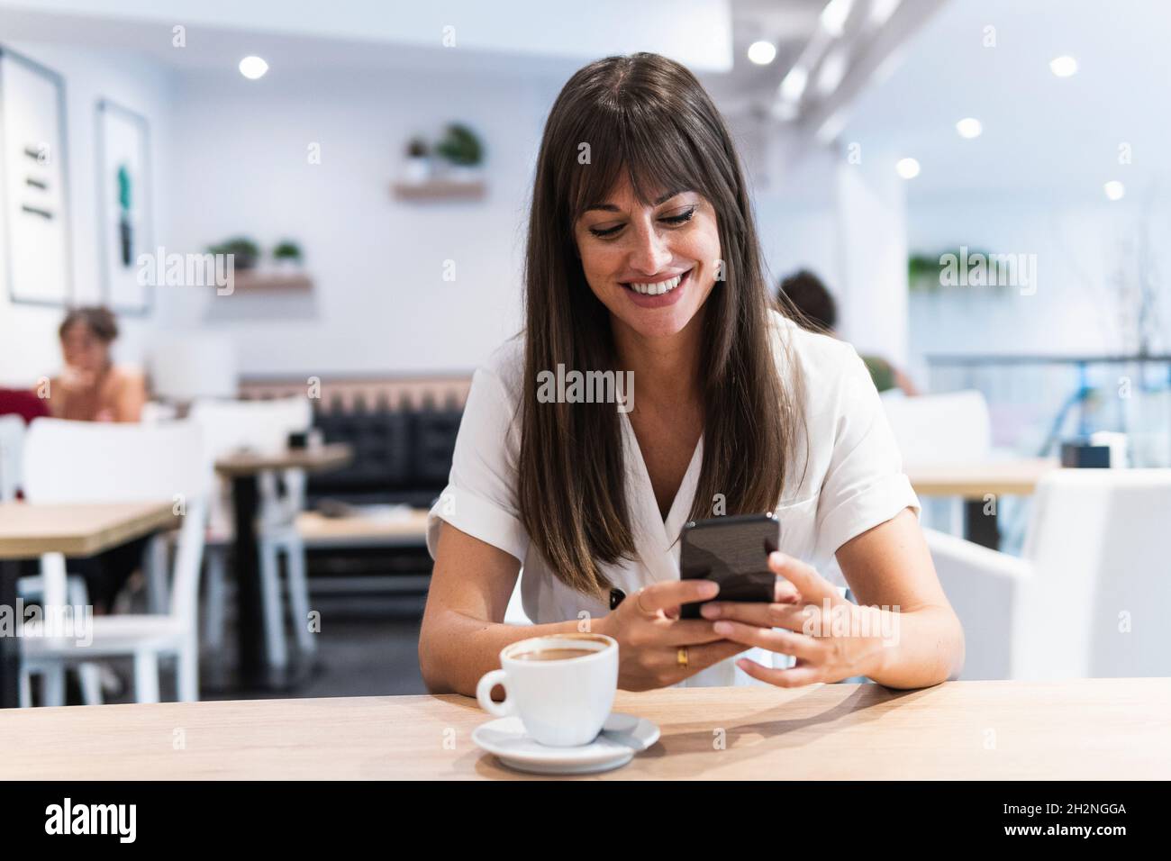 Smiling mid adult businesswoman using smart phone in restaurant Stock ...