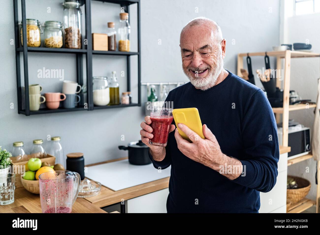 Man drinking smoothie while standing at kitchen counter Stock Photo - Alamy