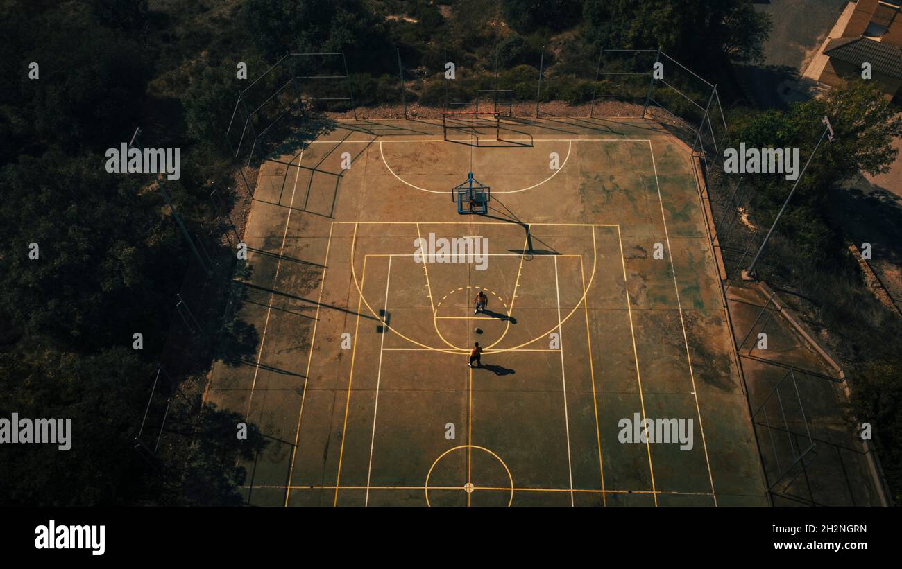 Male friends playing basketball at sports field Stock Photo - Alamy