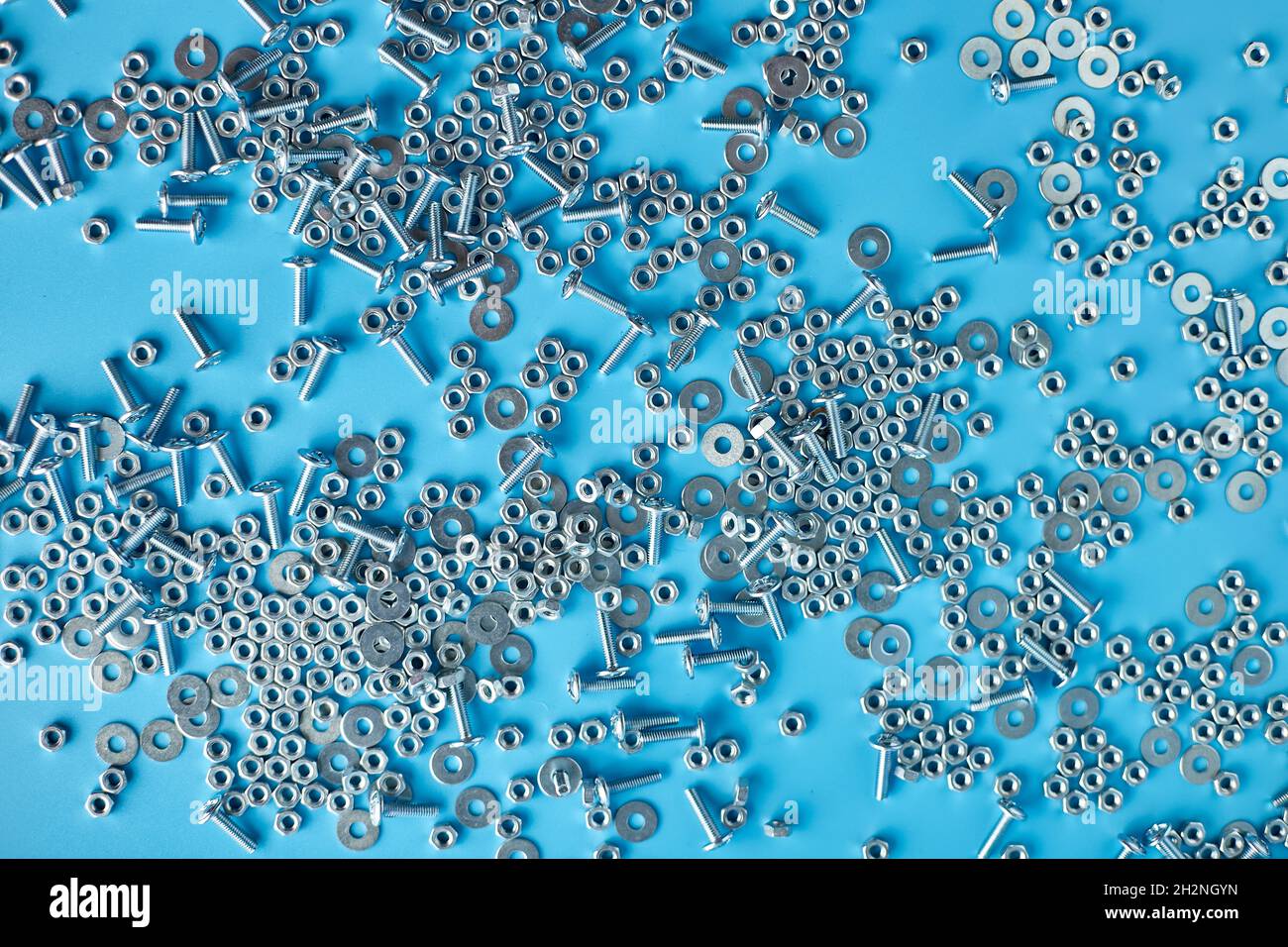 Top view, flat lay Metal screw, nuts and bolts on blue background ...