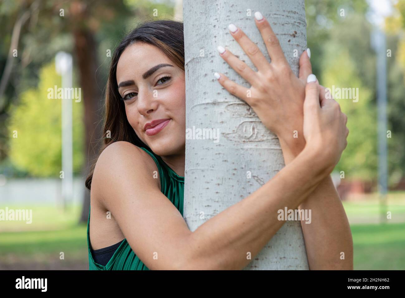 Young woman hugging tree trunk hi-res stock photography and images - Alamy