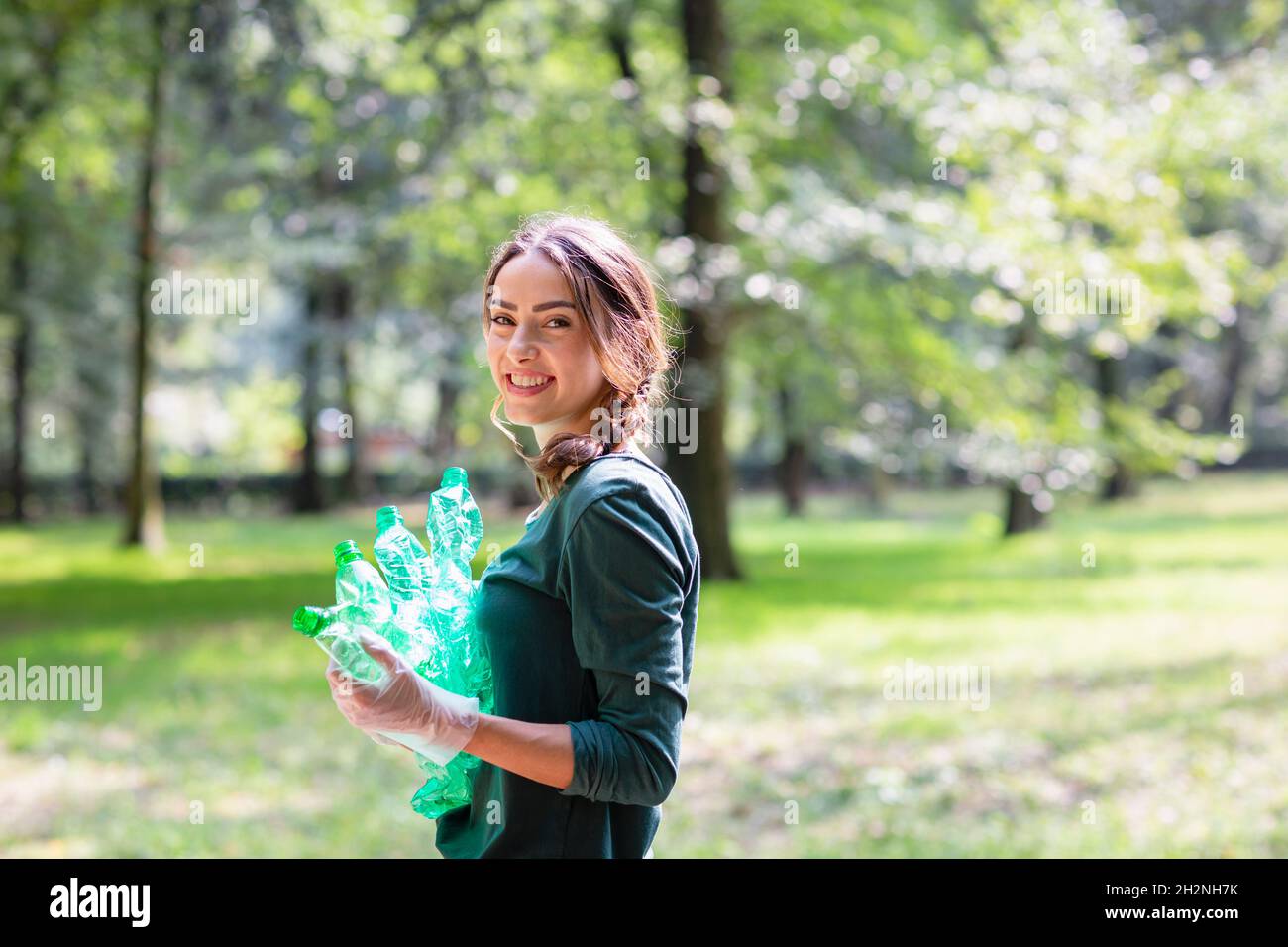 Female environmentalist holding plastic bottles at park Stock Photo - Alamy