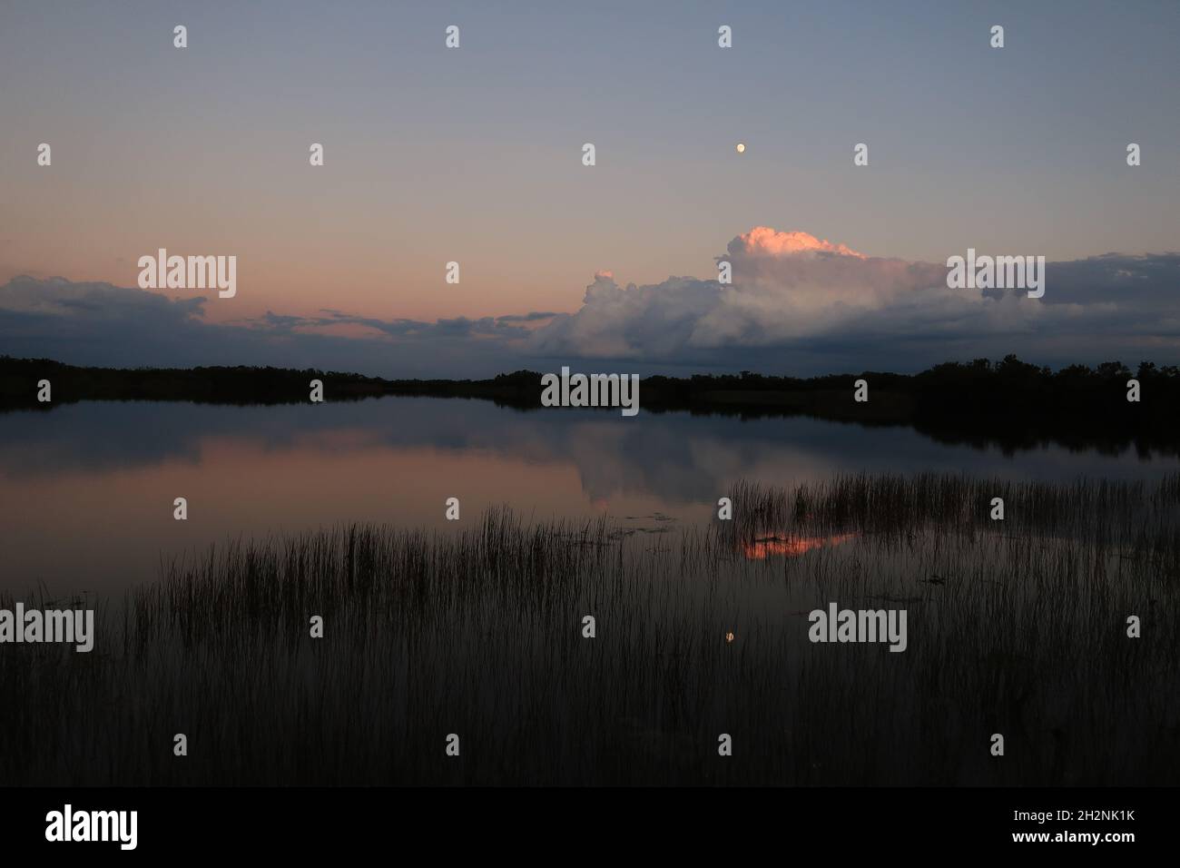 Moonrise over colorful autumn clouds reflected on calm water of Nine ...