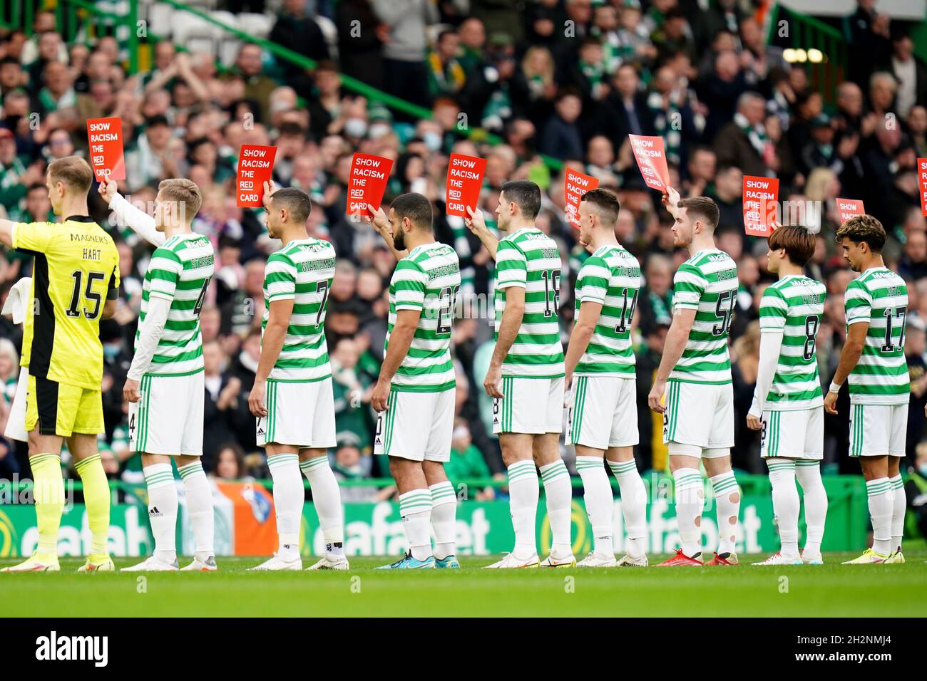 Celtic players hold up giant red cards saying "show racism the red card ...
