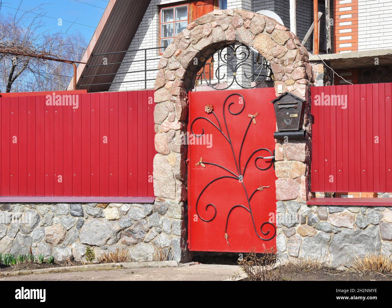 Metal Fence Door with red wild stone. Metal fencing exterior with door ...