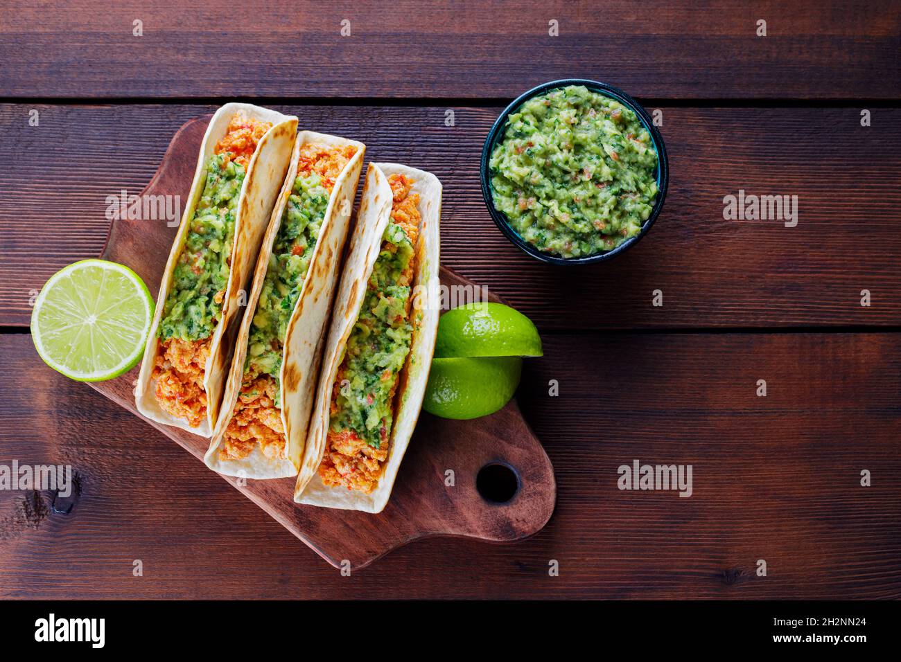 Mexican tacos with fried minced chicken and guacamole sauce on a wooden ...