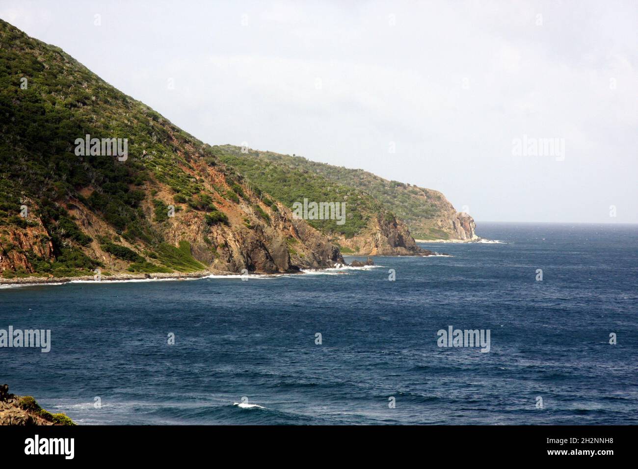 Natural view of a huge island and a deep blue coast under a white sky ...