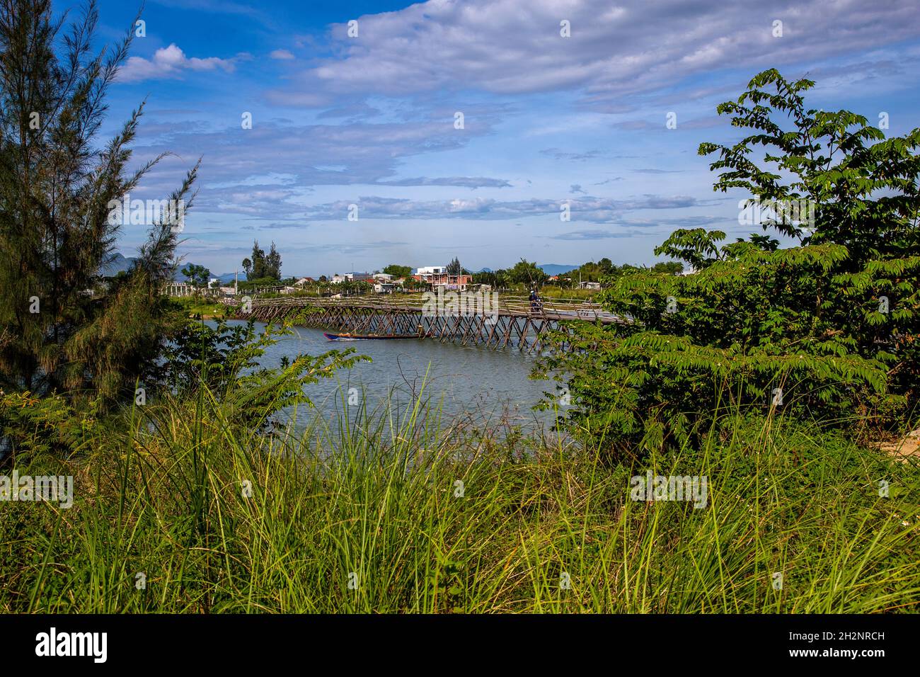 A small inlet on Cam Kim island with a wood bridge crossing Stock Photo ...