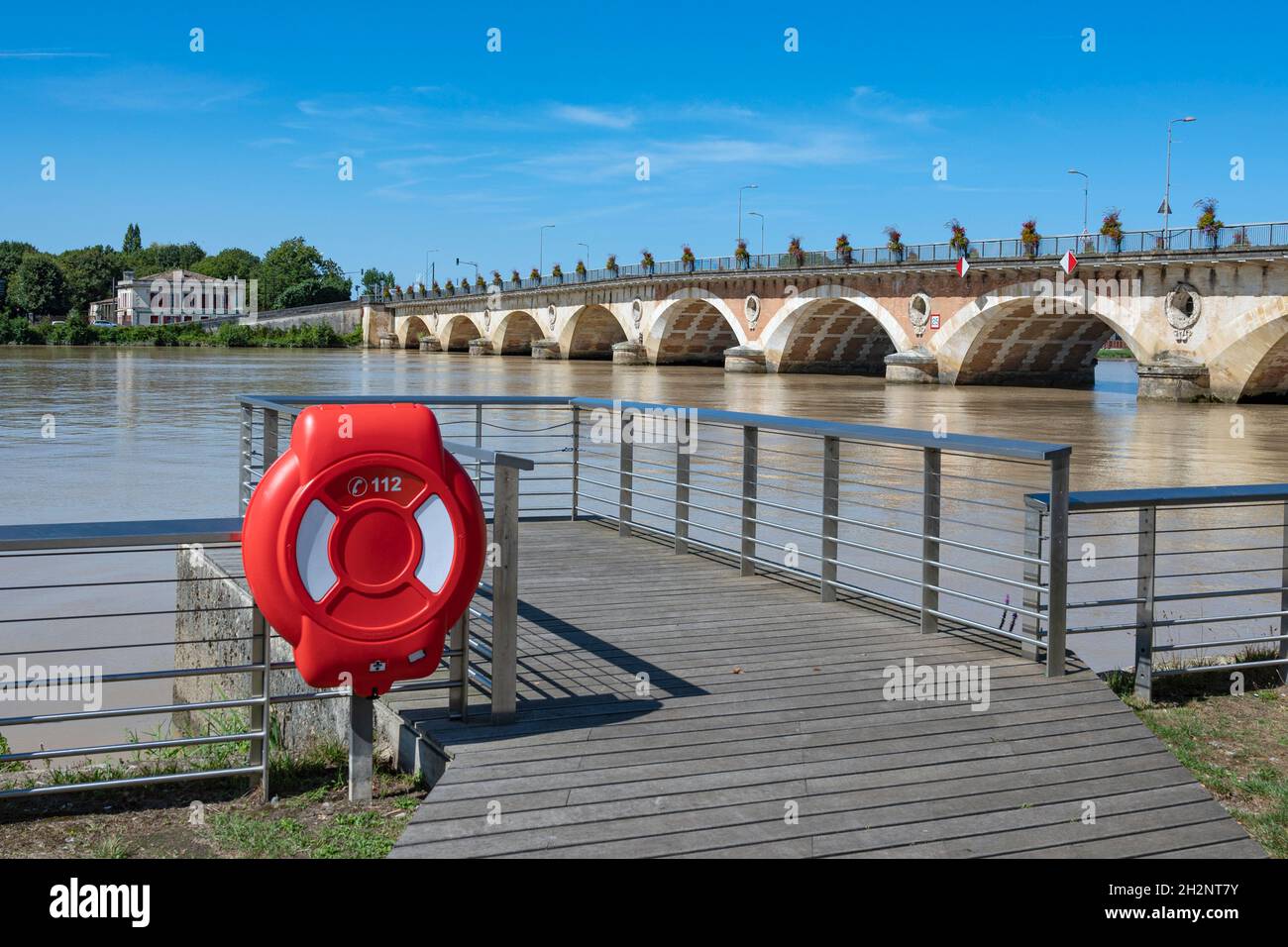 The arches of the stone bridge crossing the Dordogne river in Libourne ...