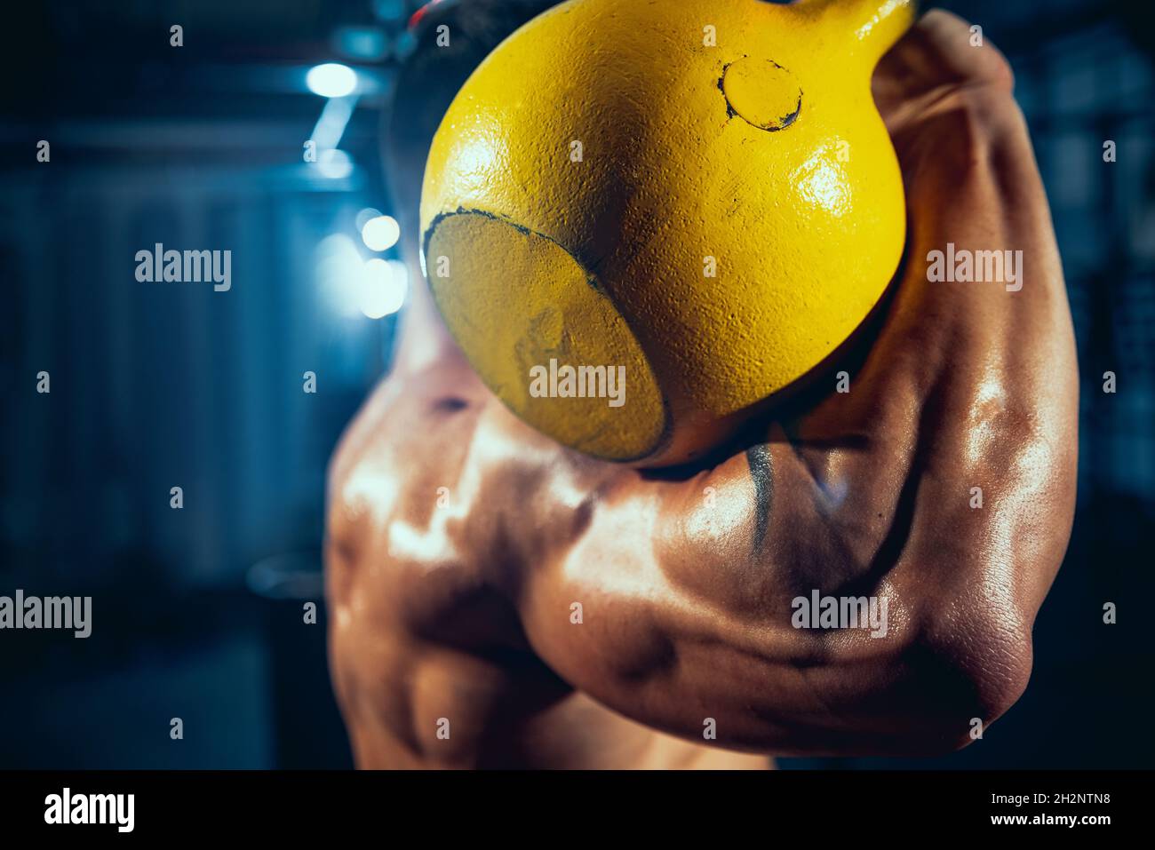 Cropped portrait of muscled athlete, bodybuilder workouts alone at ...