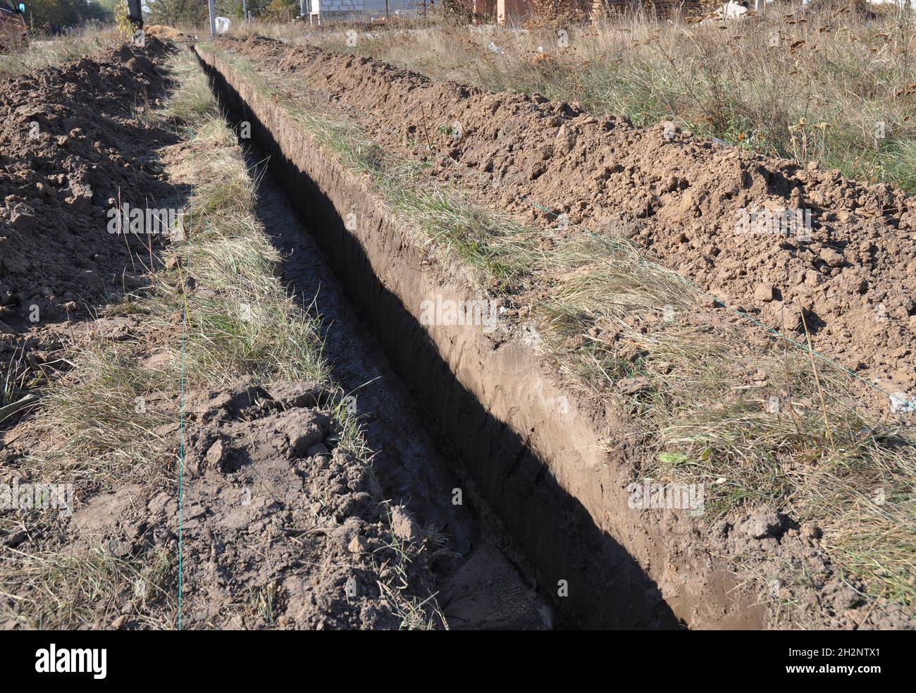 Earthworks, digging trench. Long earthen trench dug to lay pipe or ...