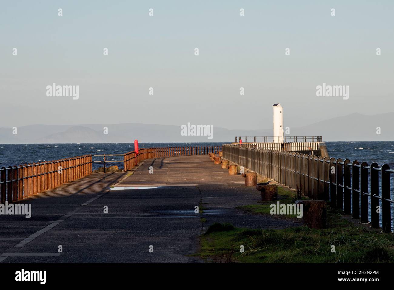 Jetty and harbour light on an autumn morning Stock Photo - Alamy