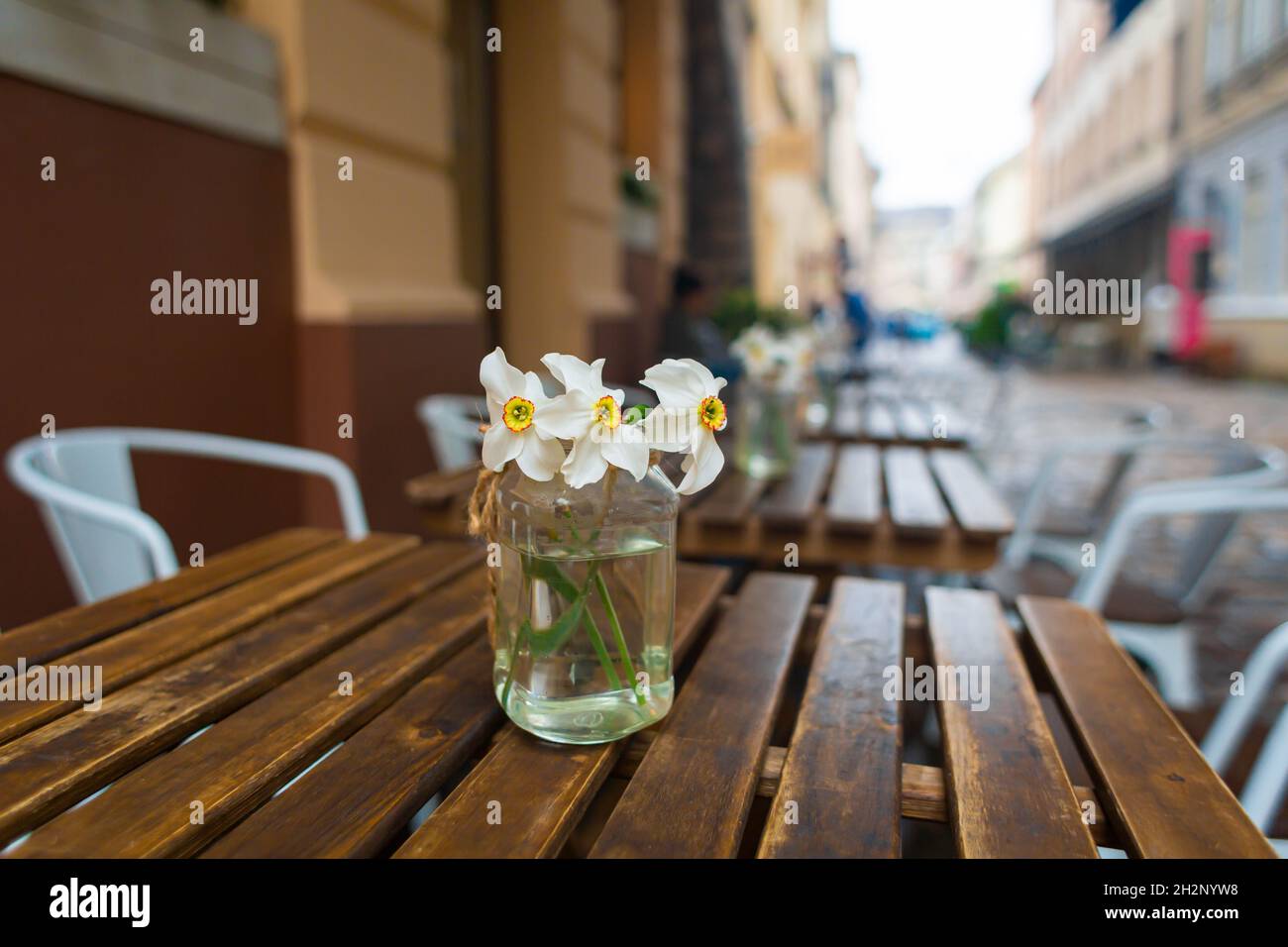 Glass vase with flowers on the wooden table of the restaurant on the ...