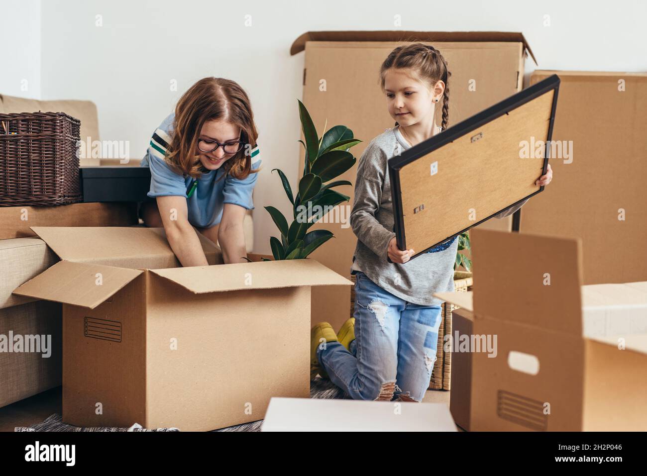 Family unpacking cardboard boxes at new home Stock Photo - Alamy