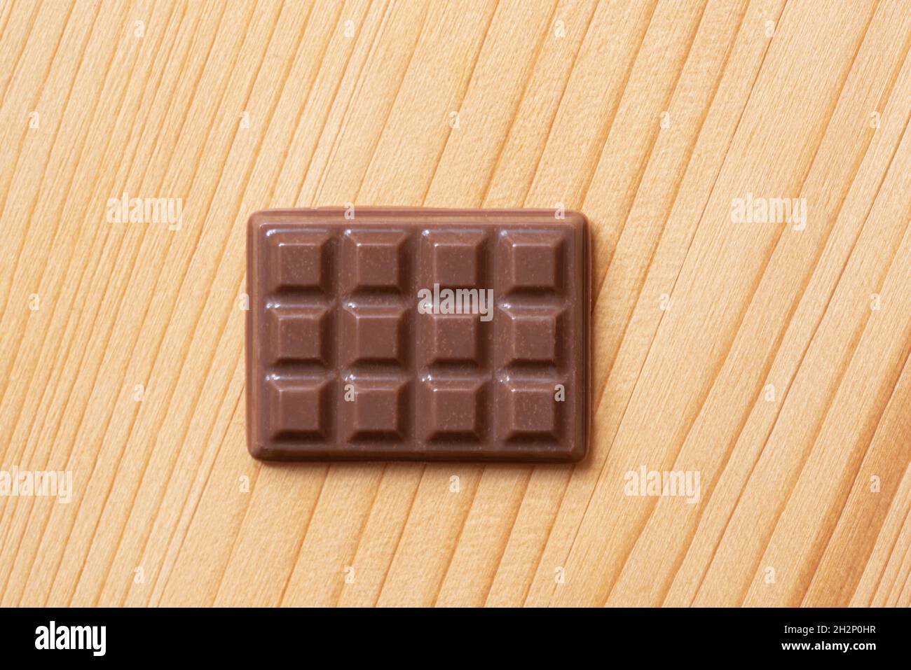 Milk chocolate tablet on a wooden table, 12 squares Stock Photo - Alamy