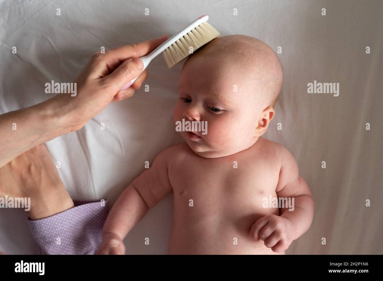 Hairbrush and baby care. Mother combing newborn hair Stock Photo - Alamy