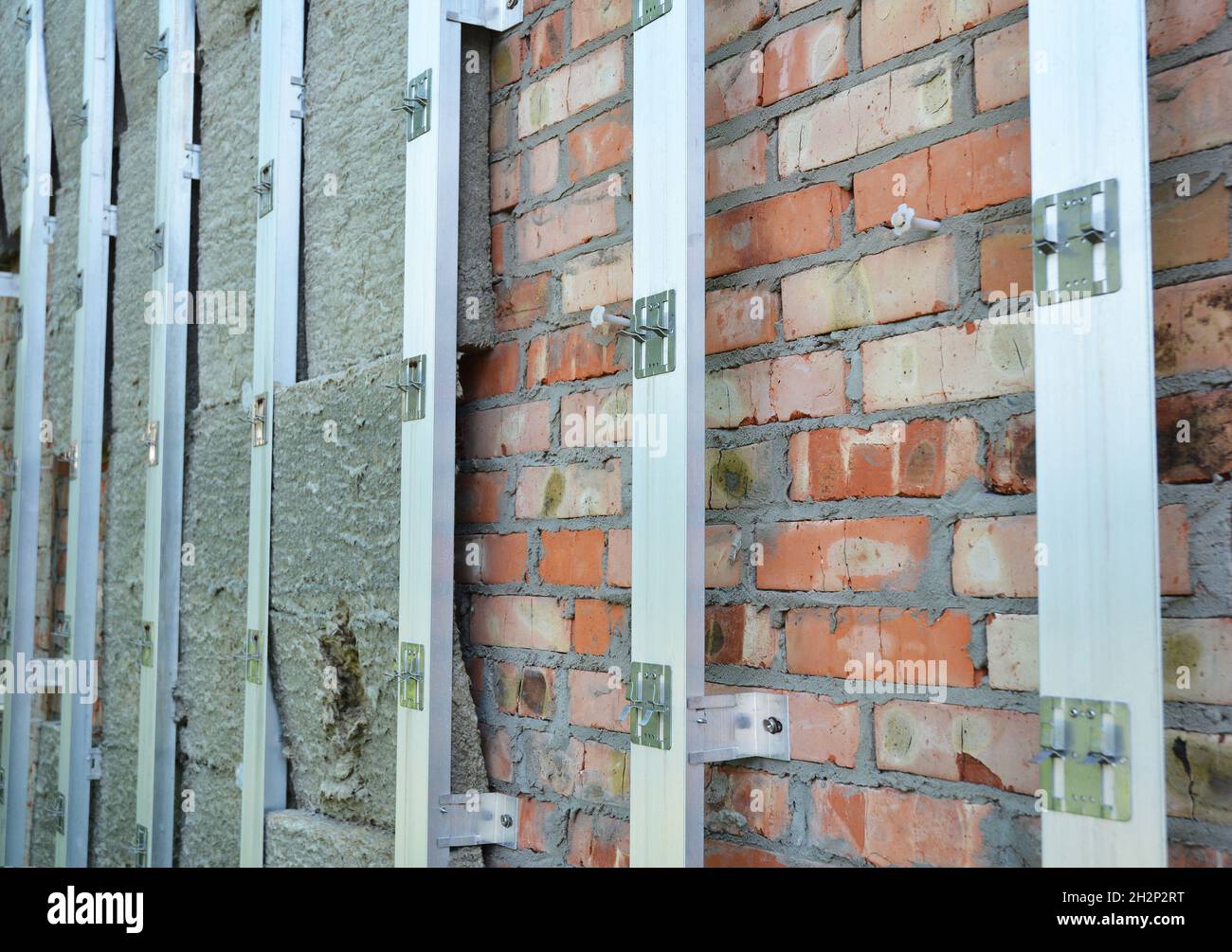 Insulating Construction. House brick wall insulation for energy saving. Renovation and ...