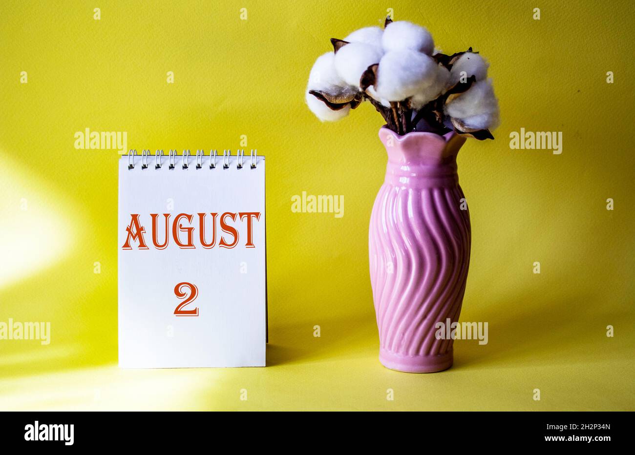 Calendar with text 2 august on yellow background and with a vase of ...