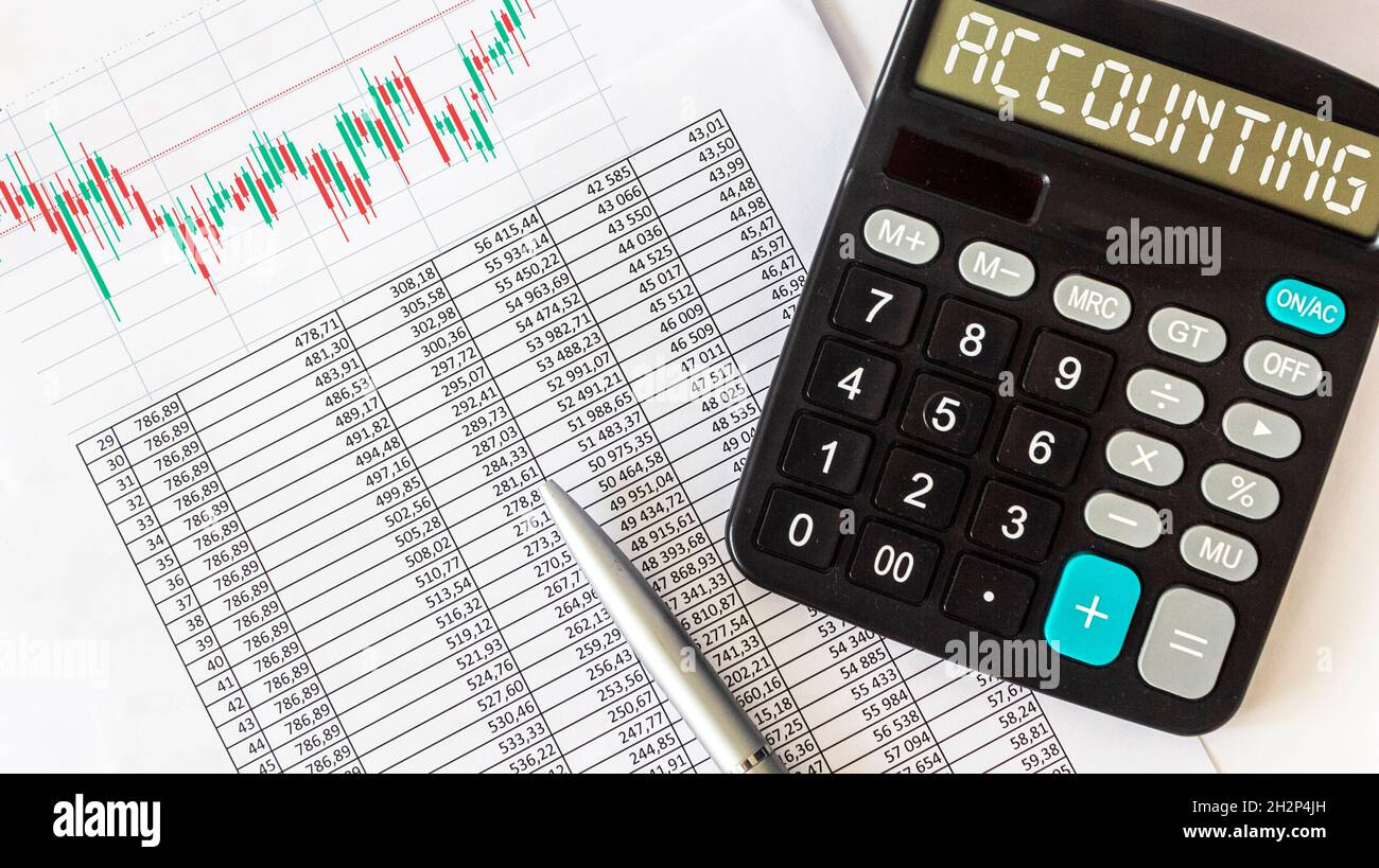 Text on accounting calculator, pen and charts with reports on a white ...