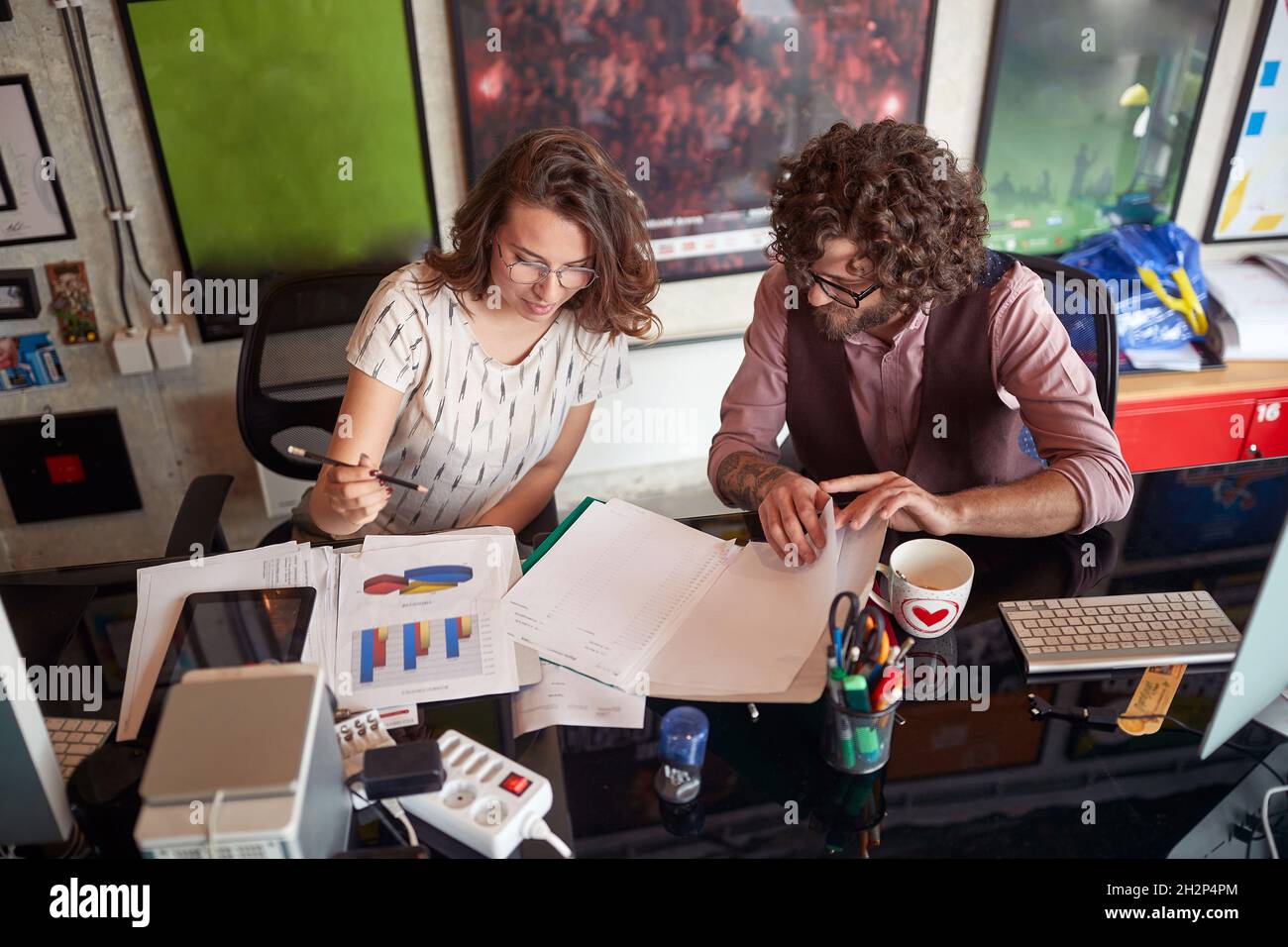 Two young colleagues doing paperwork togetherin the office Stock Photo ...