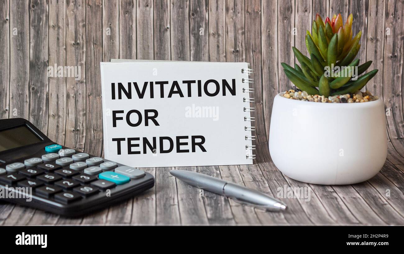 Notepad with text INVITATION TO TENDER on wooden background with ...