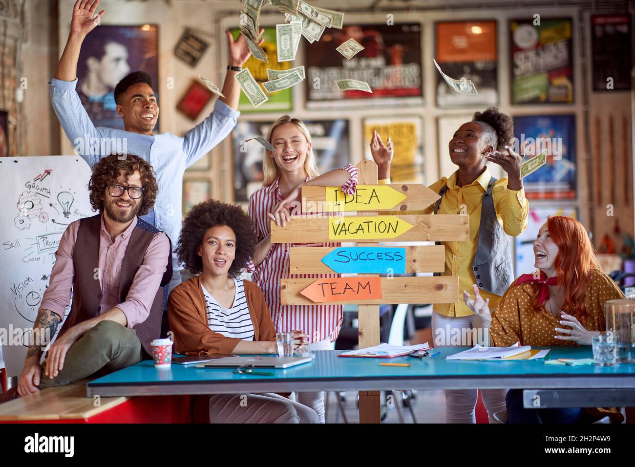 Group of young creative people is throwing money while posing for a ...