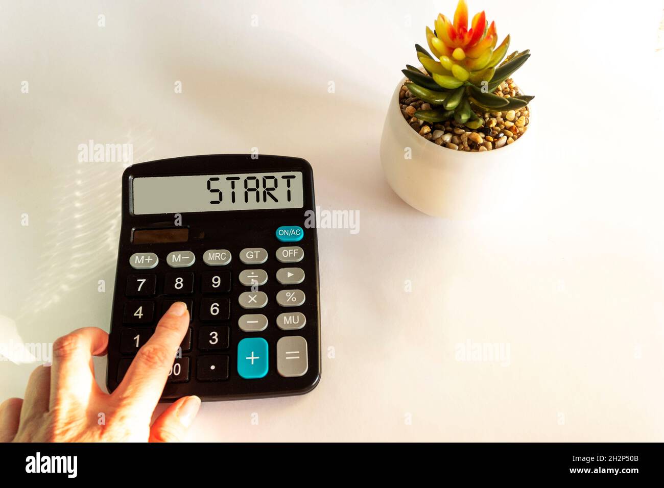 A calculator with text Start on the display. Business and financial ...