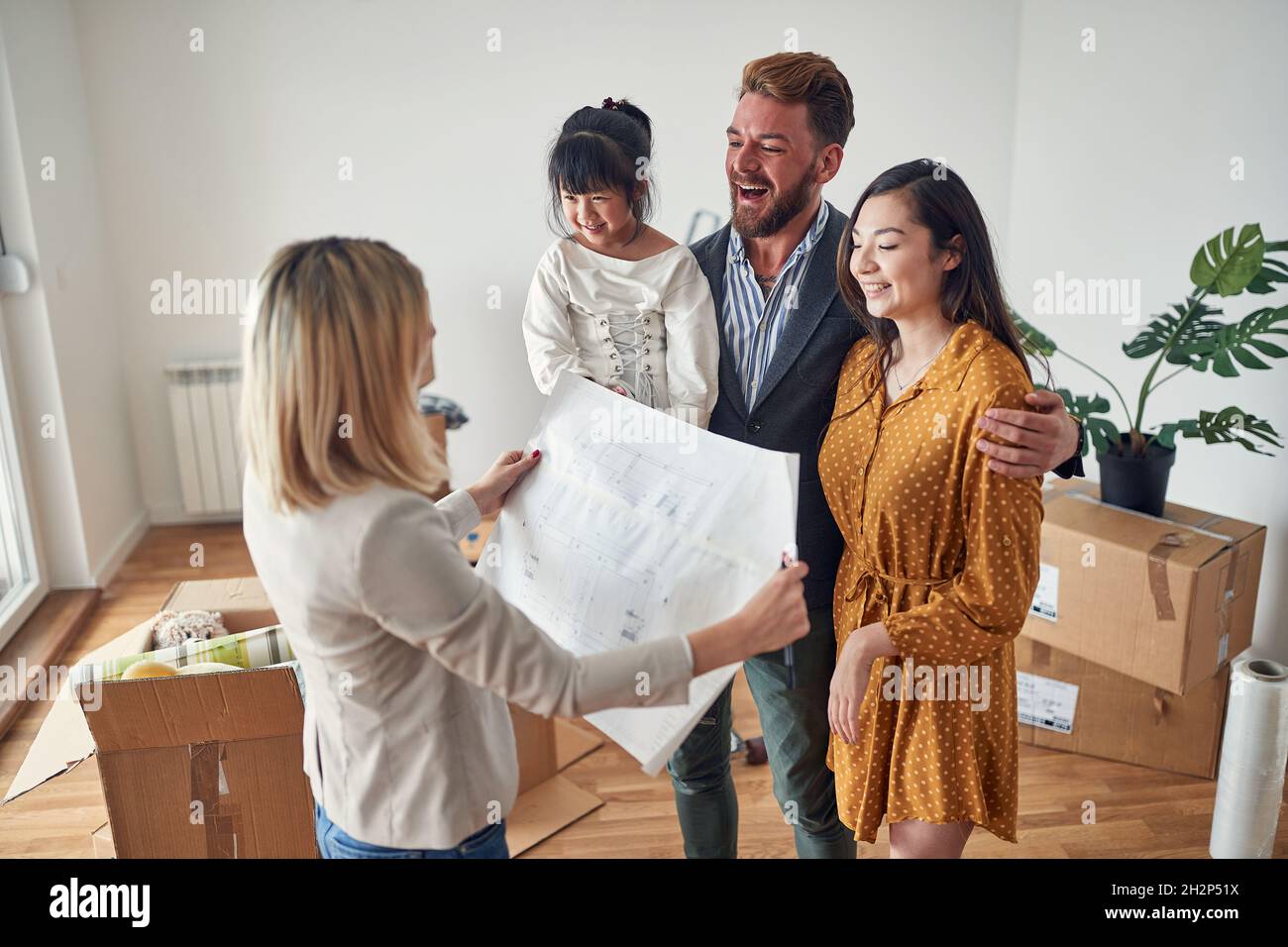 Cheerful multi ethnic family moving in together into new home; New ...
