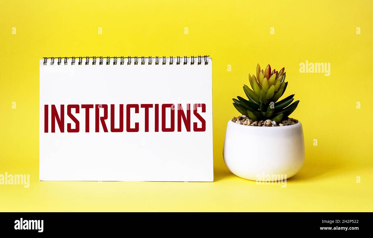 The word INSTRUCTION is written in a notebook on a yellow background ...