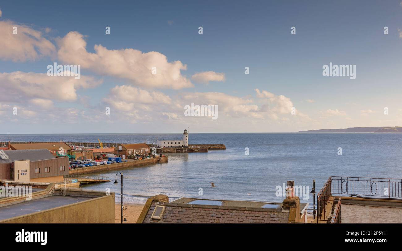 View of seaside bay and harbour over the rooftops. Cliffs are on one ...