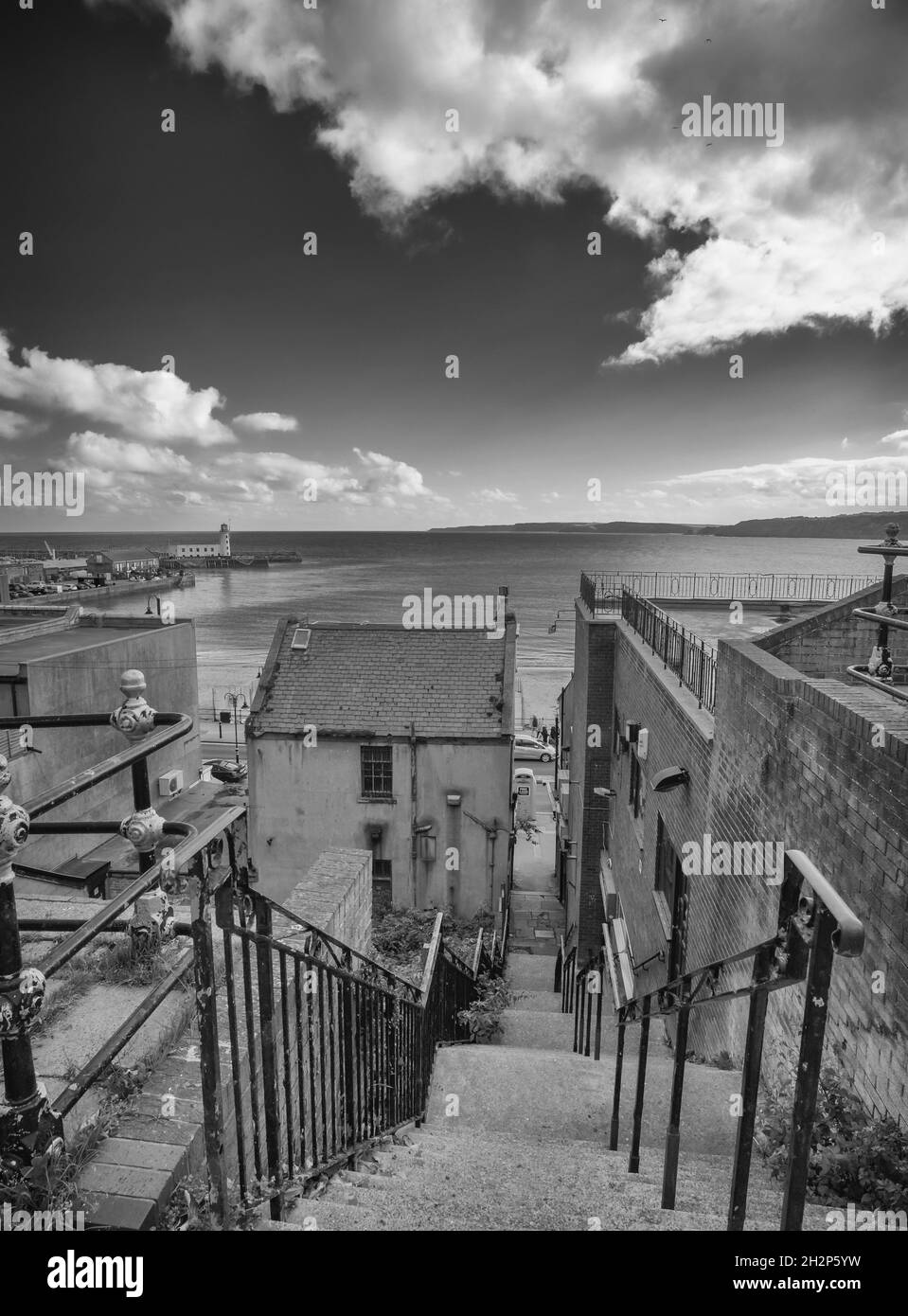 View of seaside bay and harbour from some steps. Cliffs are on one side ...