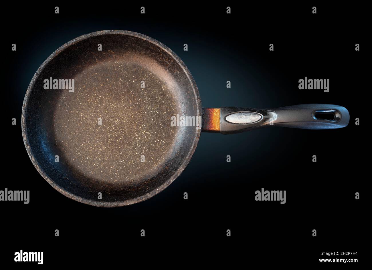 Old used worn vintage frying pan. Top view, isolated on black ...