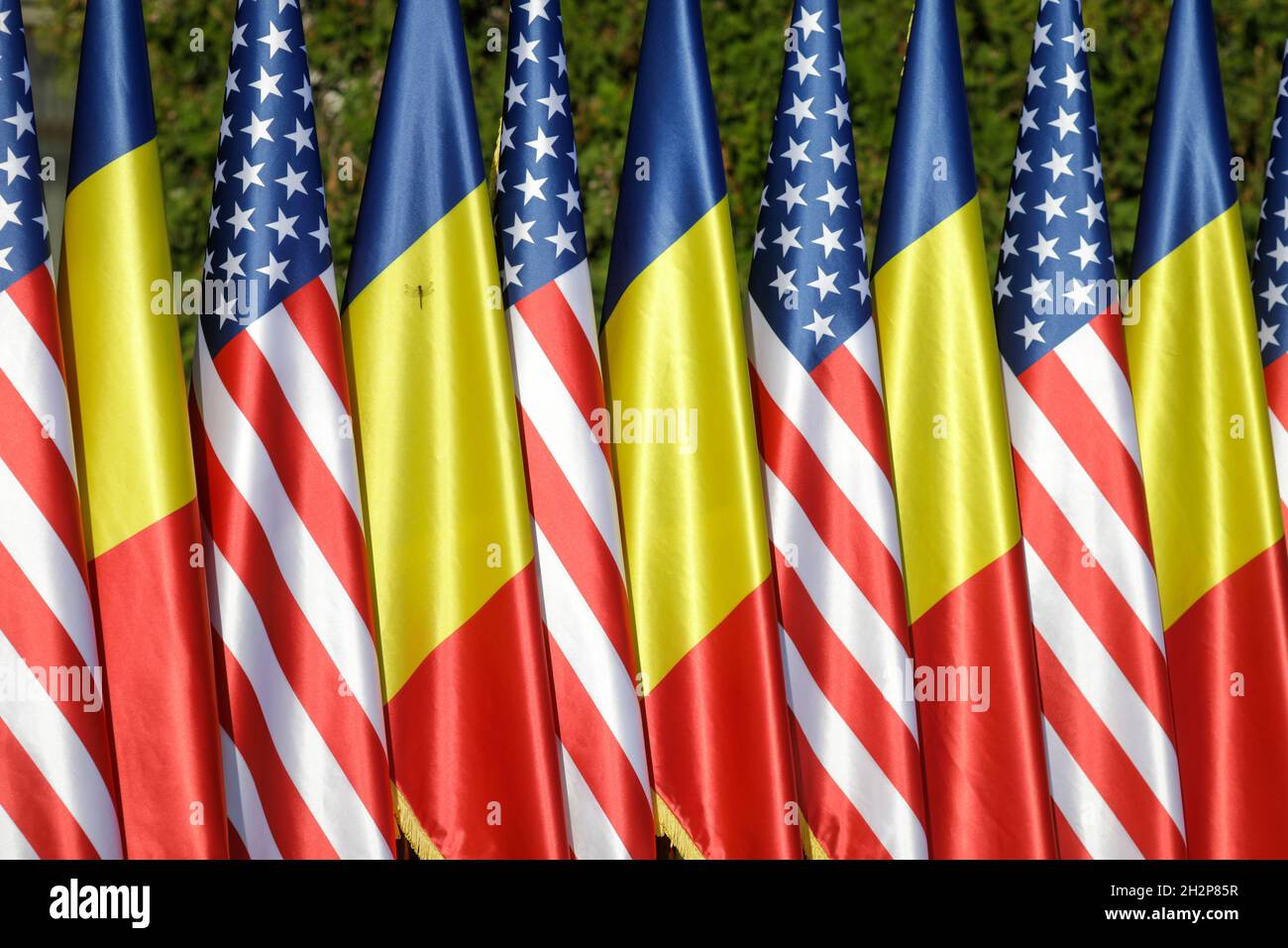 United States and Romanian flags on poles one next to another Stock ...