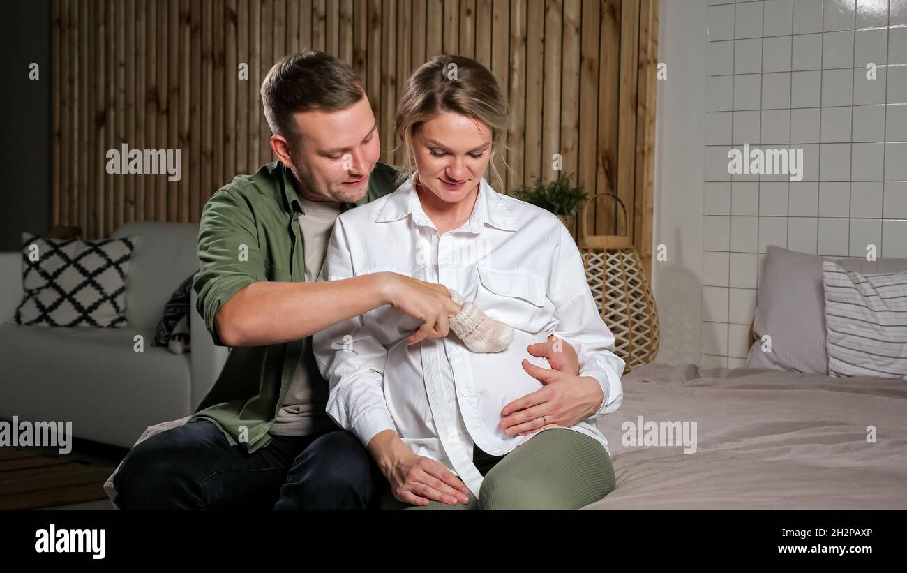 Man hand steps fingers with socks across pregnant lady belly Stock ...
