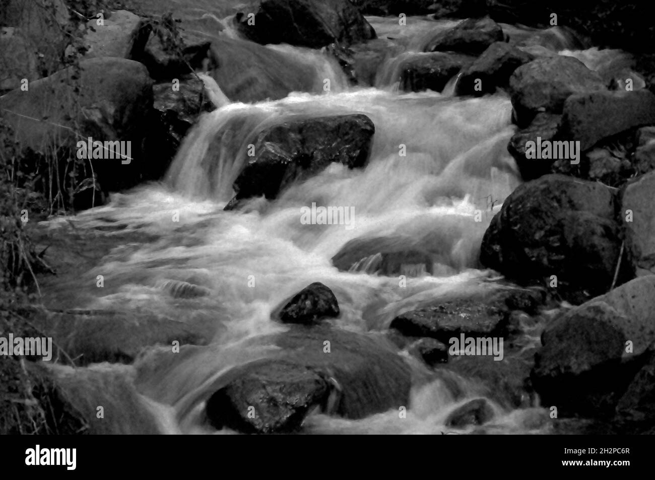 Grayscale of a river running down in a rocky area Stock Photo - Alamy