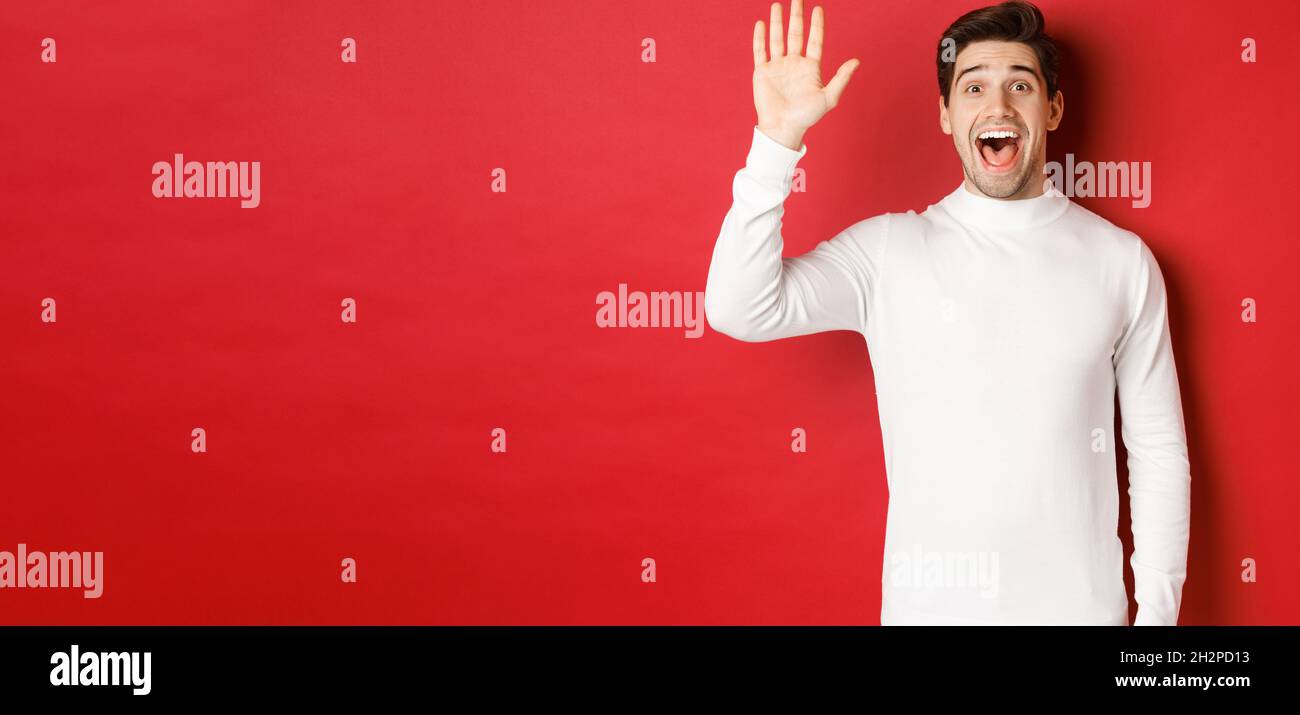 Image of happy and friendly young man saying hello, waving hand to ...