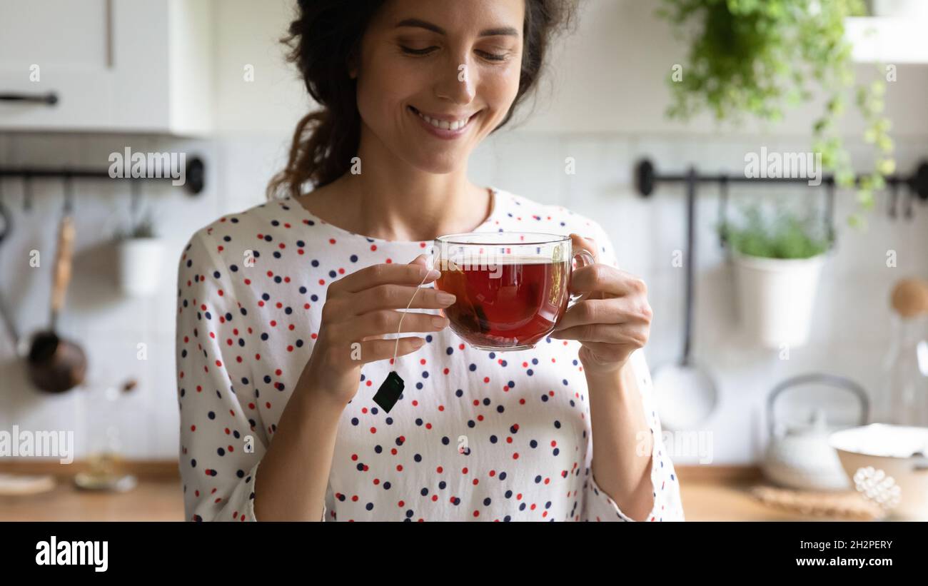 Happy woman taking tea break, holding glass mug Stock Photo - Alamy