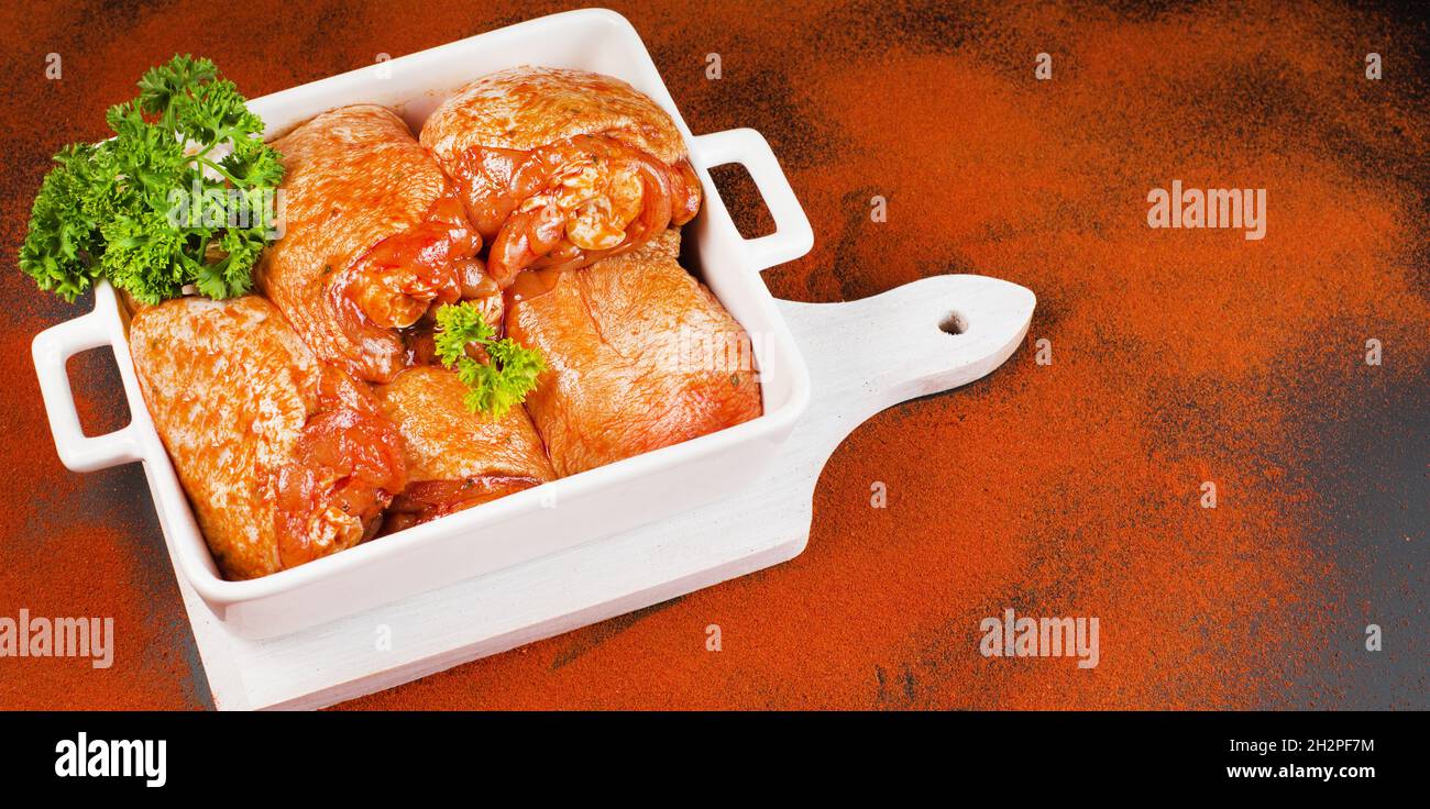 Chicken semi-cooked thighs. Raw chicken thighs marinated in red sauce ...