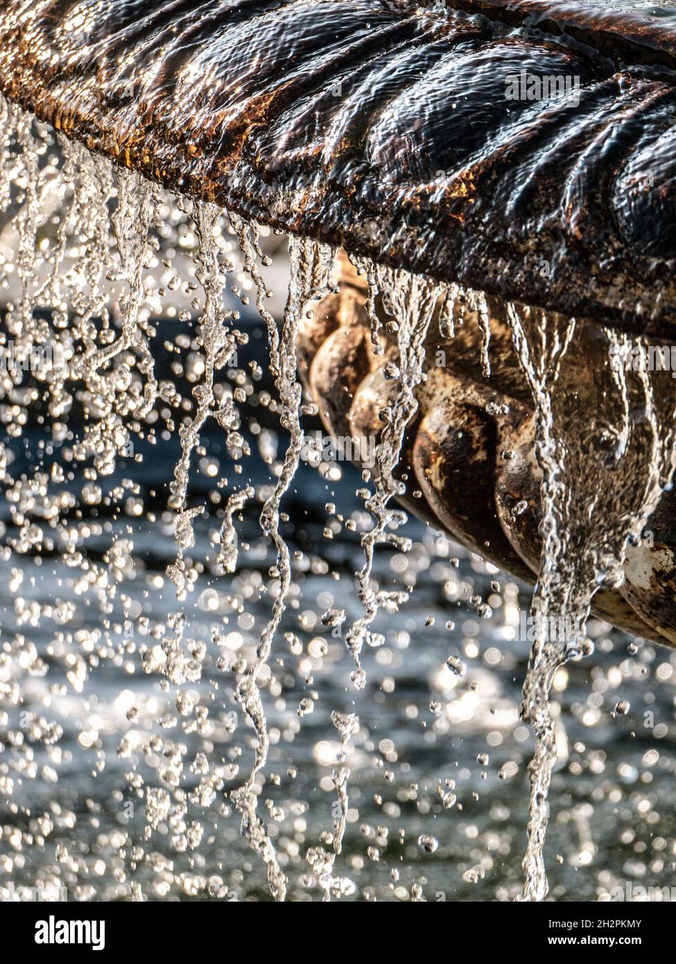 WATER FOUNTAIN ACTION DROPS DROPLETS Water flowing off an ornamental ...