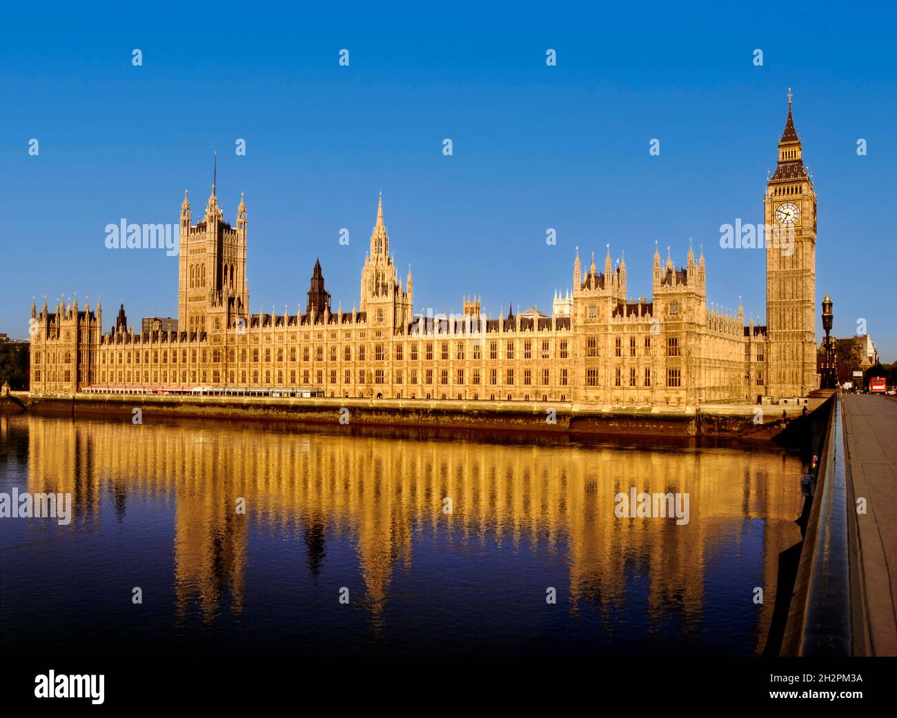Houses of Parliament London, lit by clear dawn sunrise reflected in the ...