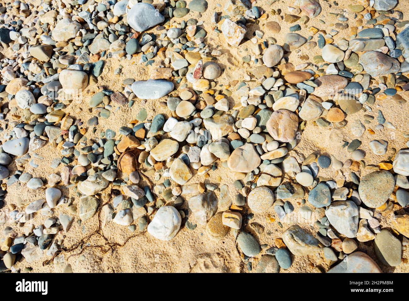 Sea stones and sand beach close-up background Stock Photo - Alamy