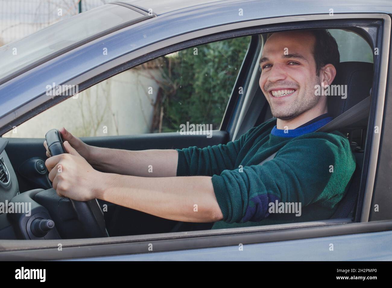 happy proud young man driving car, smiling and looking to camera Stock ...