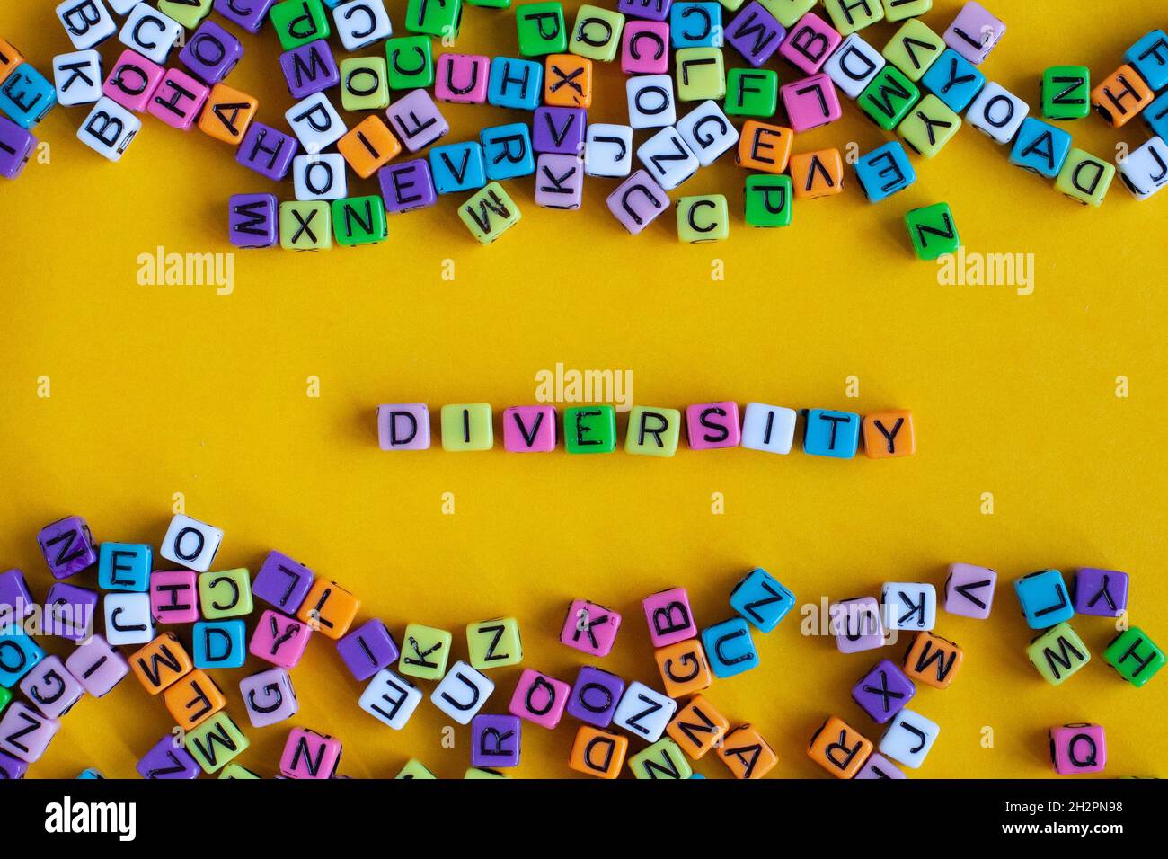 Diversity concept, word from colorful letters on yellow background ...