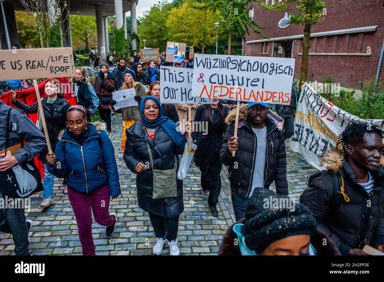 Protesters hold placards during the demonstration.'We Are Here' is a ...