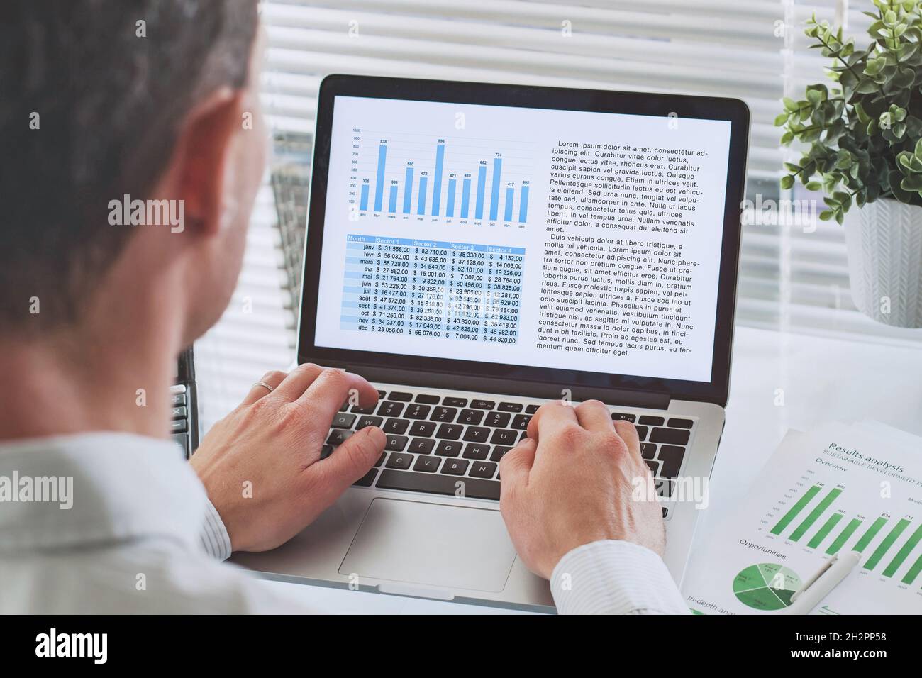 business man reading financial analytics report with charts on screen ...