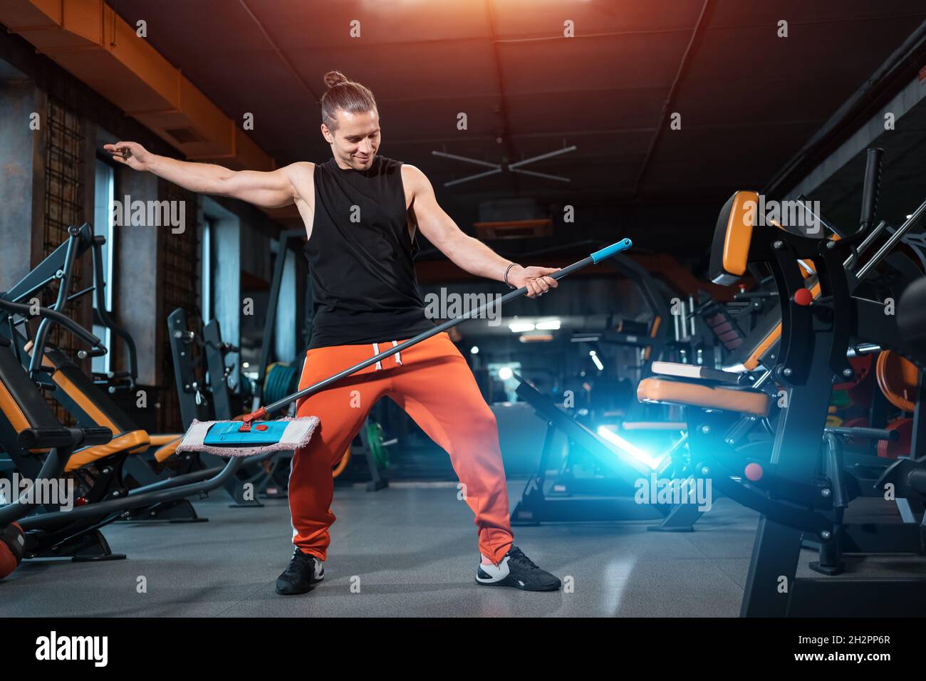 attractive male athlete cleaner have fun and dance and make cleaning in ...
