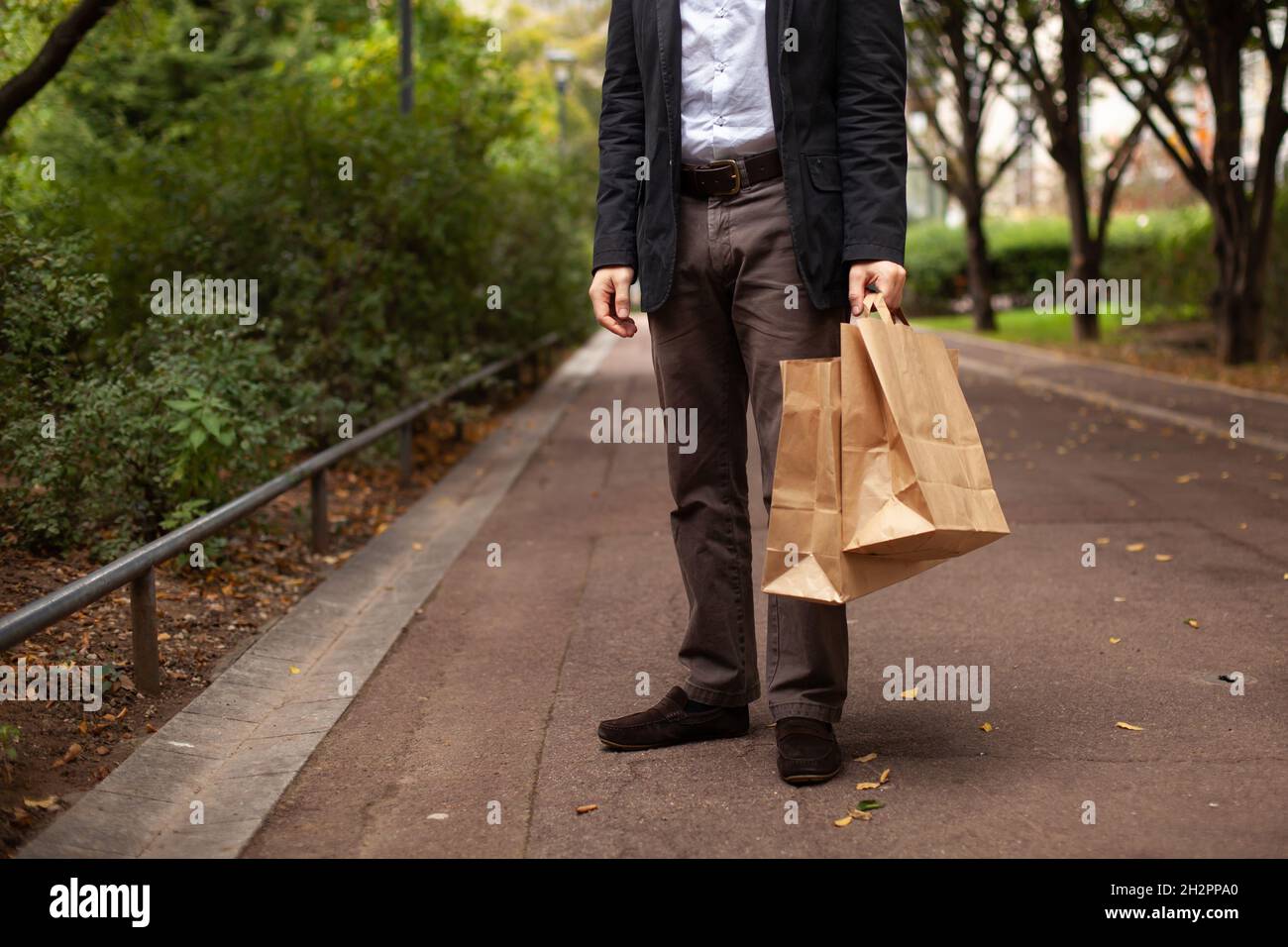 consumerism and retail, consumer holding paper shopping bags outside ...
