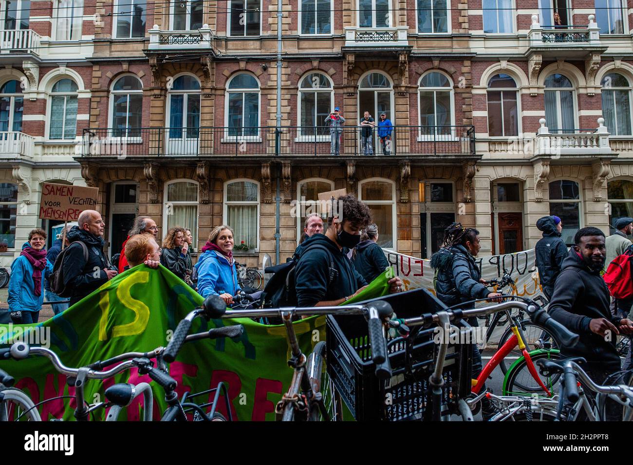 Protesters hold a banner during the demonstration.'We Are Here' is a ...