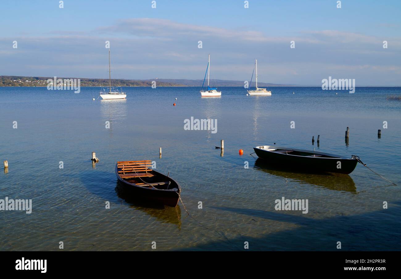 sunlit white sailing boats in Schondorf on traquil lake Ammersee with ...